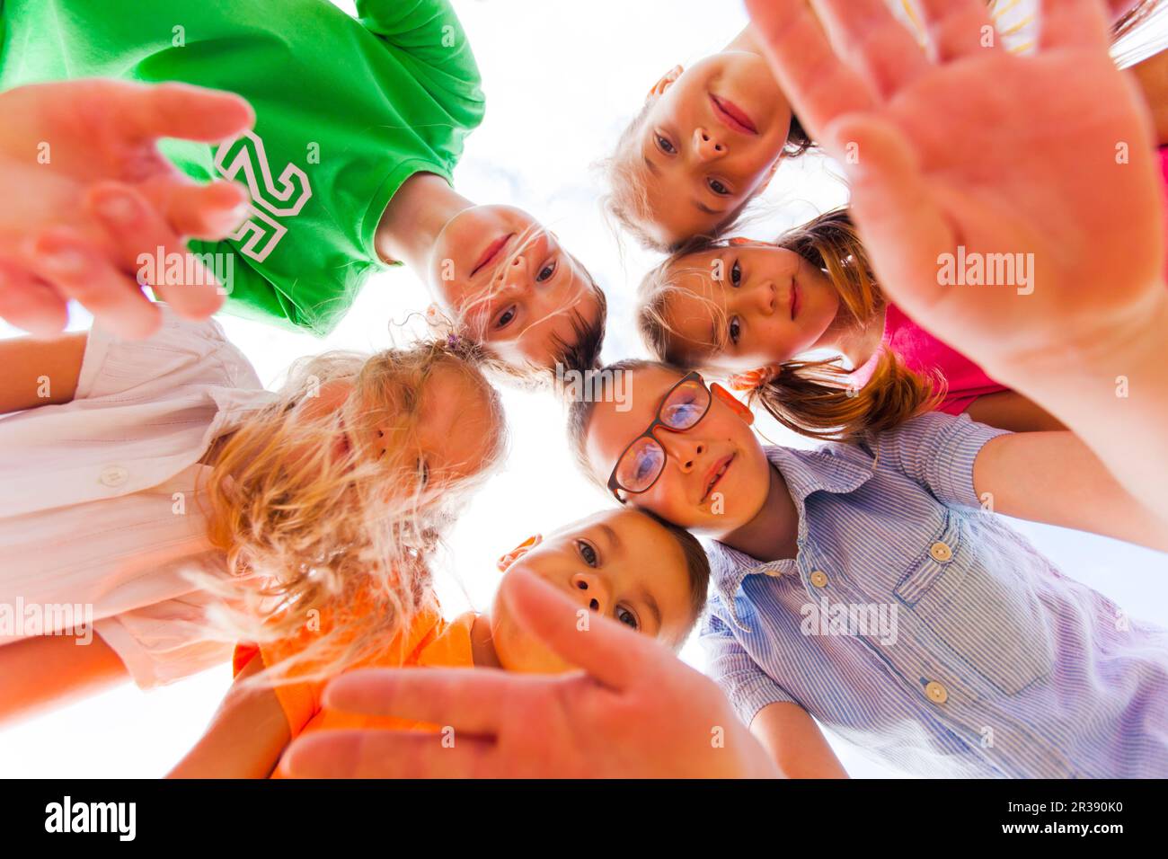 Cheerful kids standing closely in a circle touching their heads Stock ...