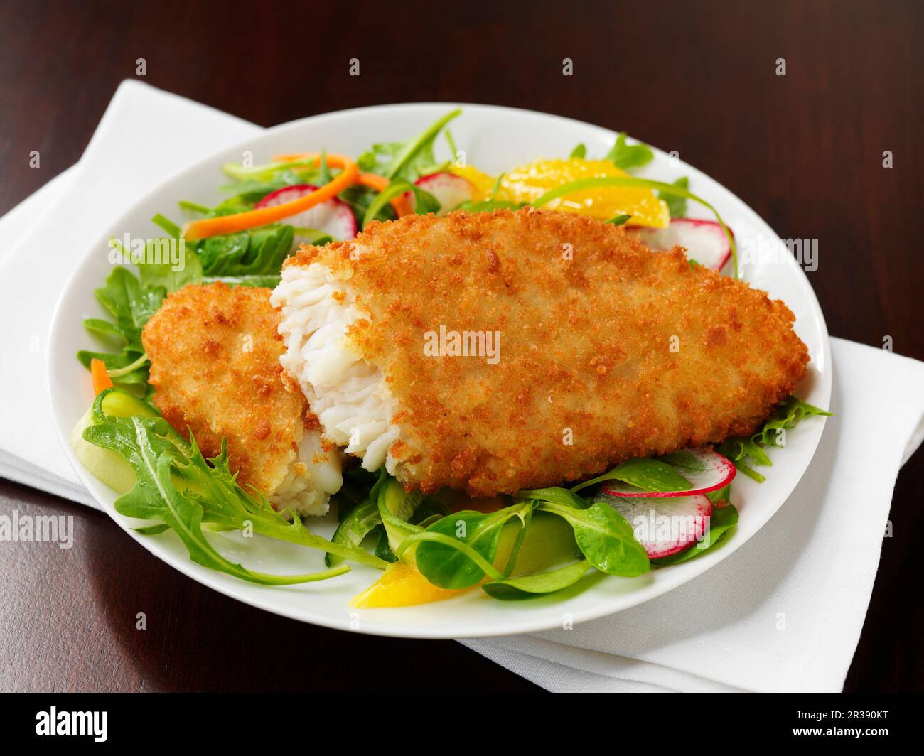 Breaded Alaska pollock on salad Stock Photo - Alamy