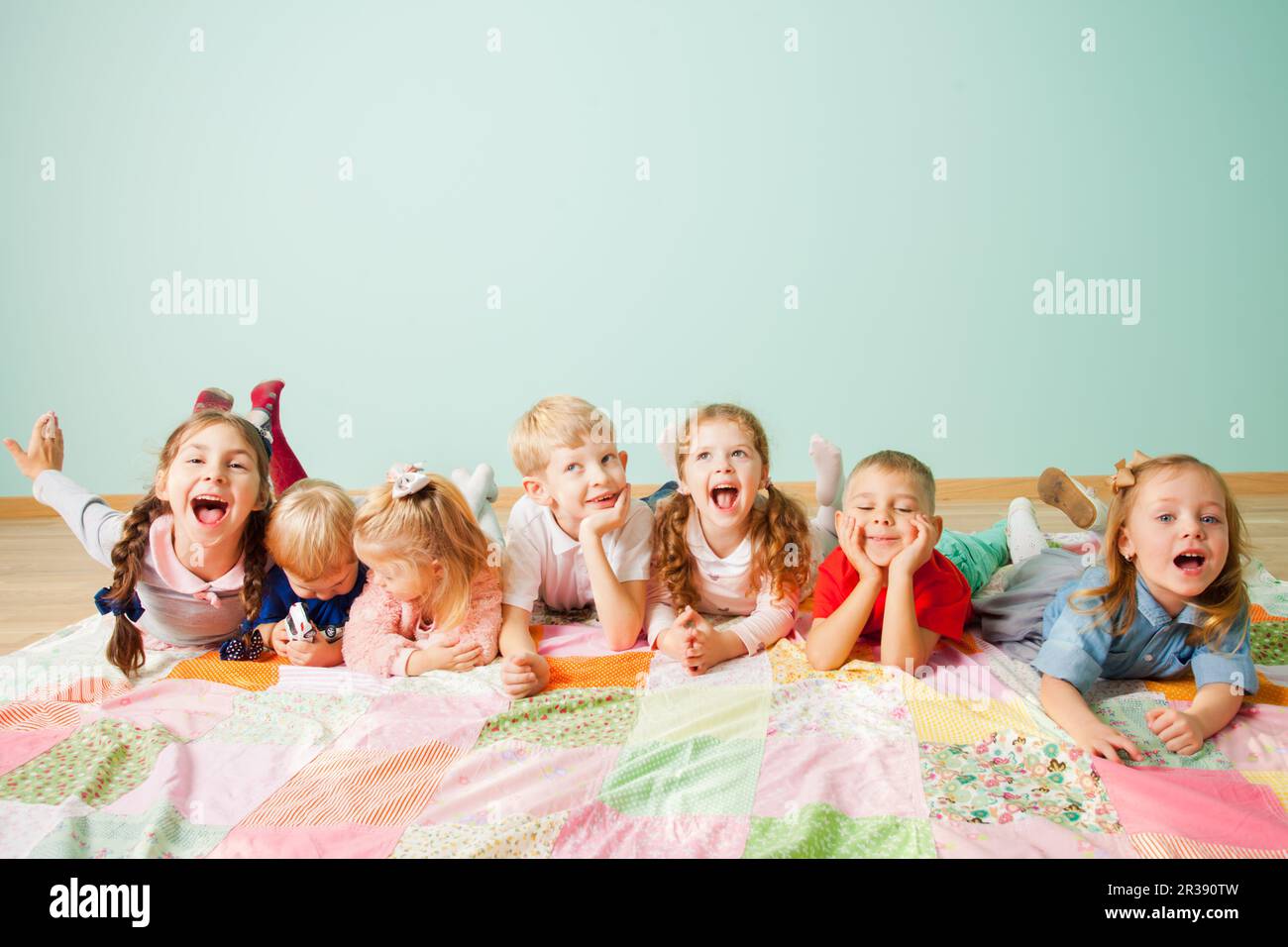 Group of laughing kids laying on floor Stock Photo - Alamy