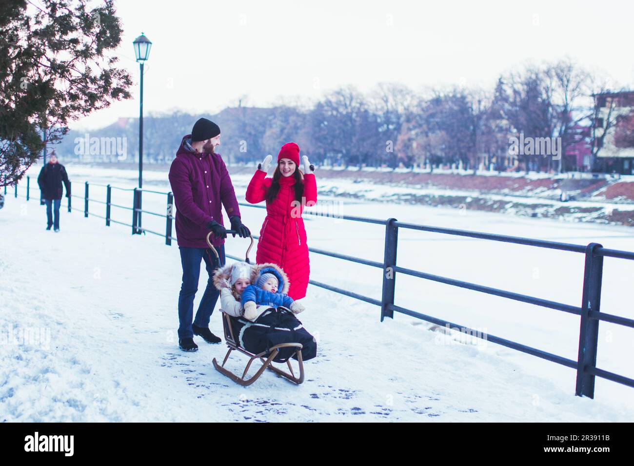 Couple pushing sled with their little children Stock Photo - Alamy
