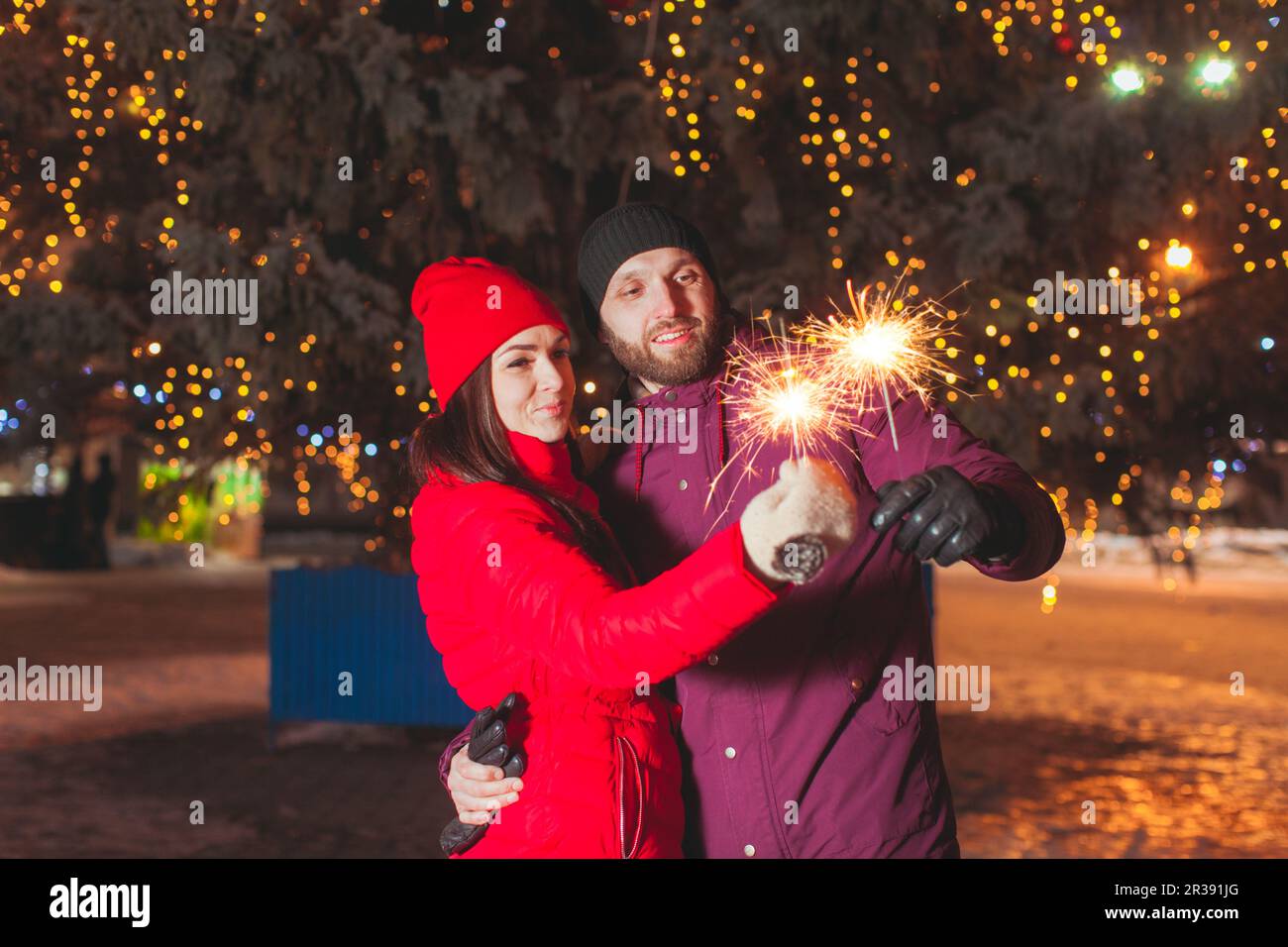 Outdoor portrait of young couple lighting sparkles Stock Photo - Alamy