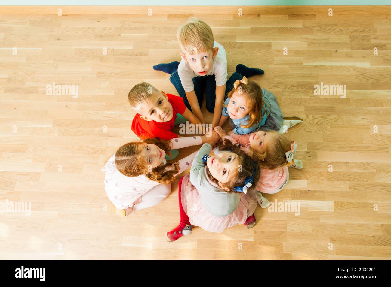 Happy kids sitting close in a circle Stock Photo - Alamy