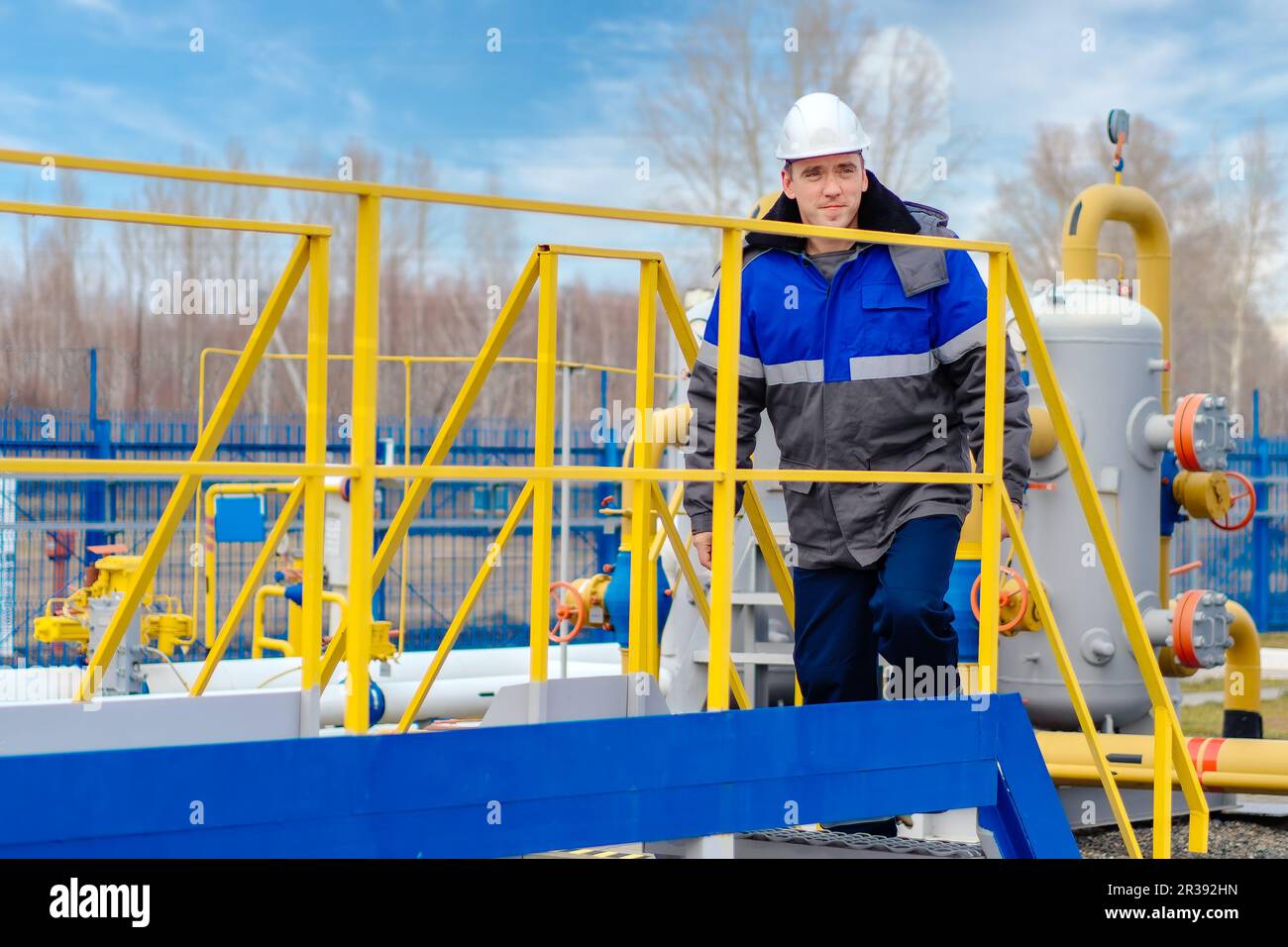 Portrait of worker in white helmet and winter pea jacket at industrial ...