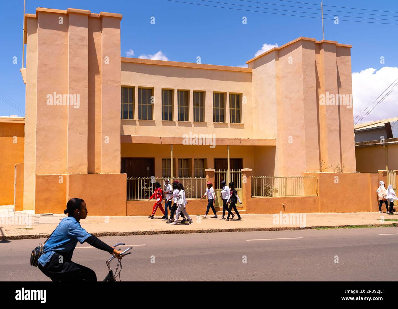 Teenagers passing in front an old italian colonial building, Central ...
