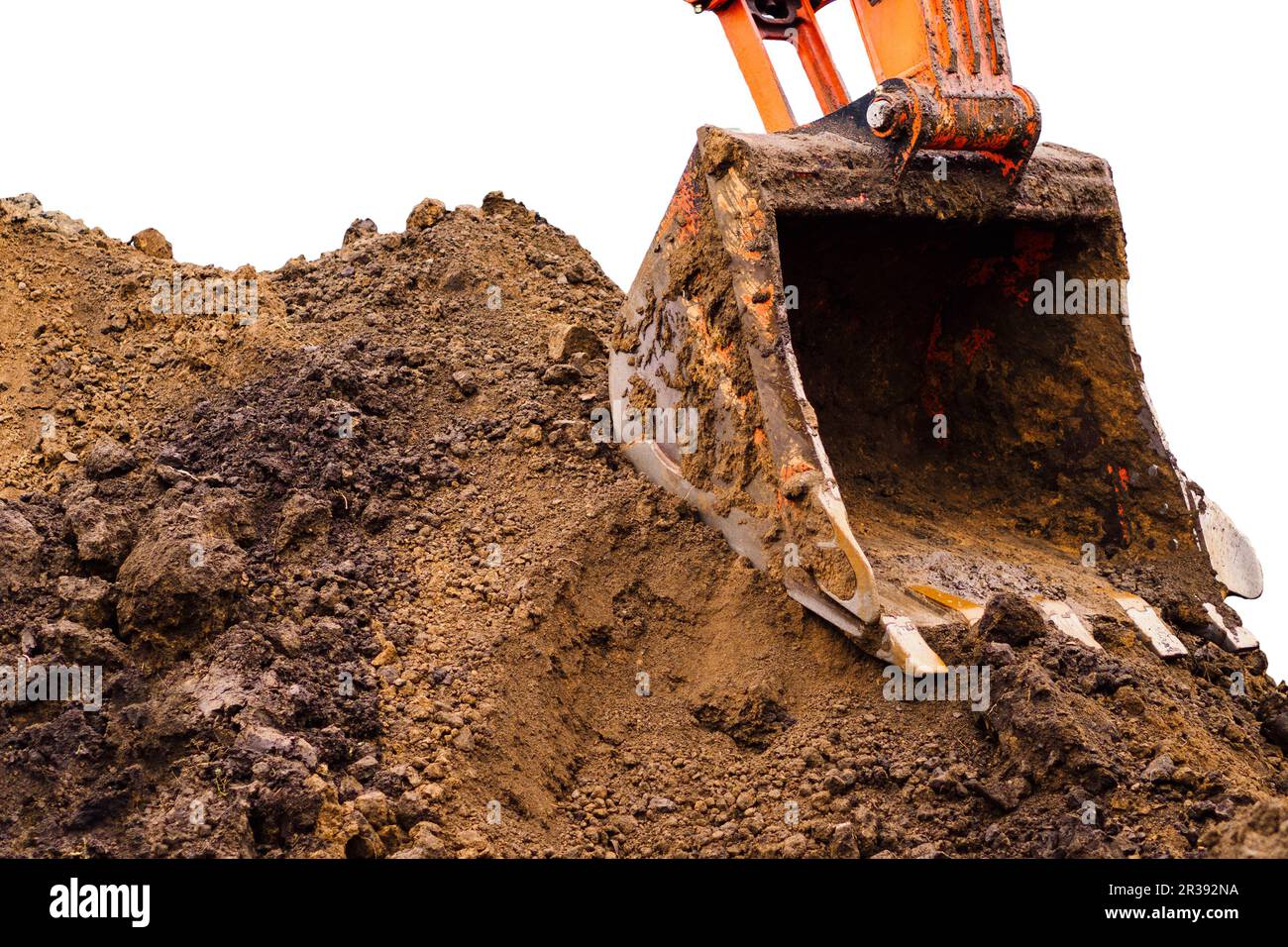 Close-up view of bulldozer bucket with pile of clay and earth. Isolated ...
