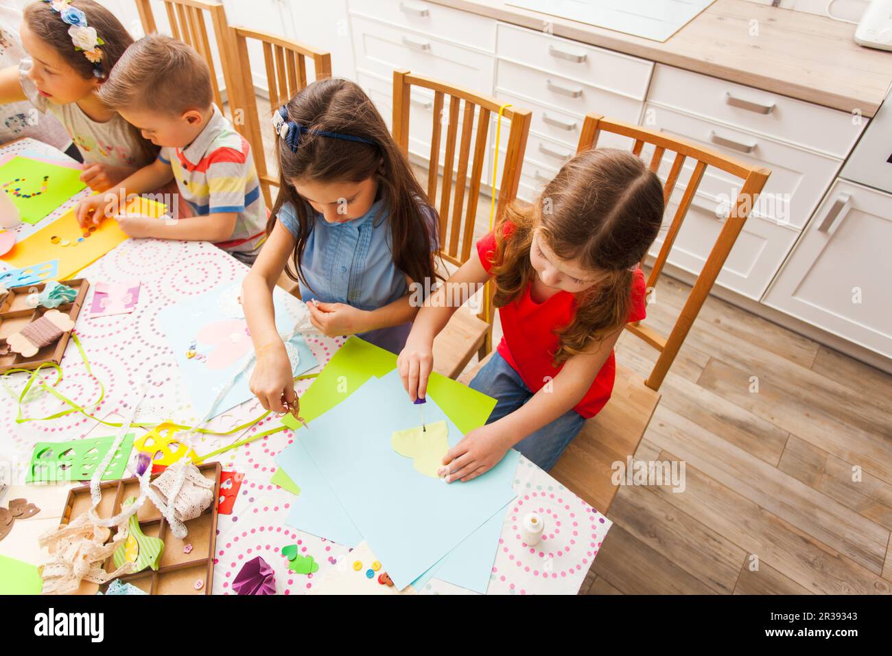 Little girls and boys make greeting cards from carton in a team Stock ...