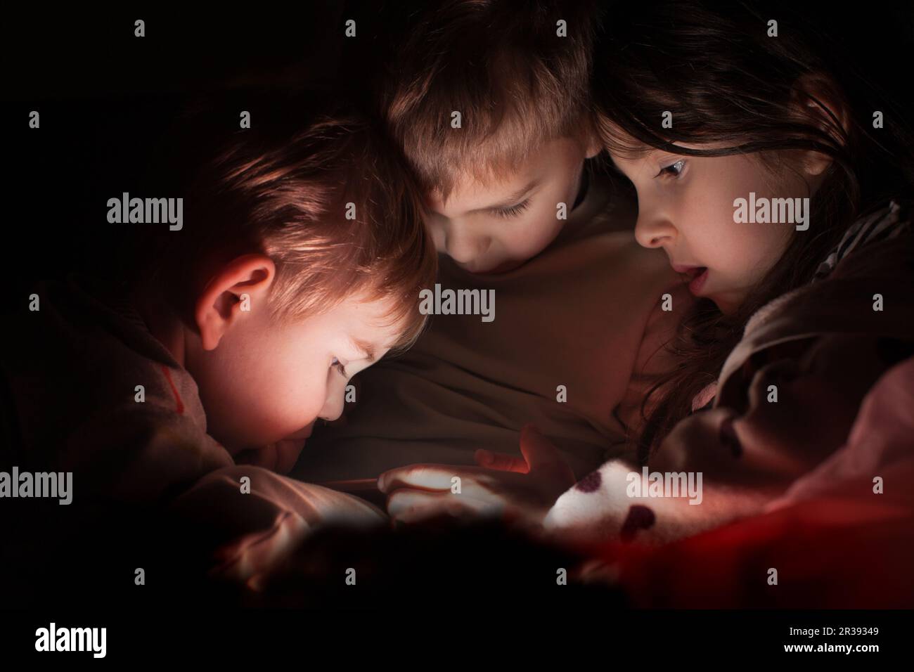 Kids playing games in a smartphone in the night Stock Photo - Alamy