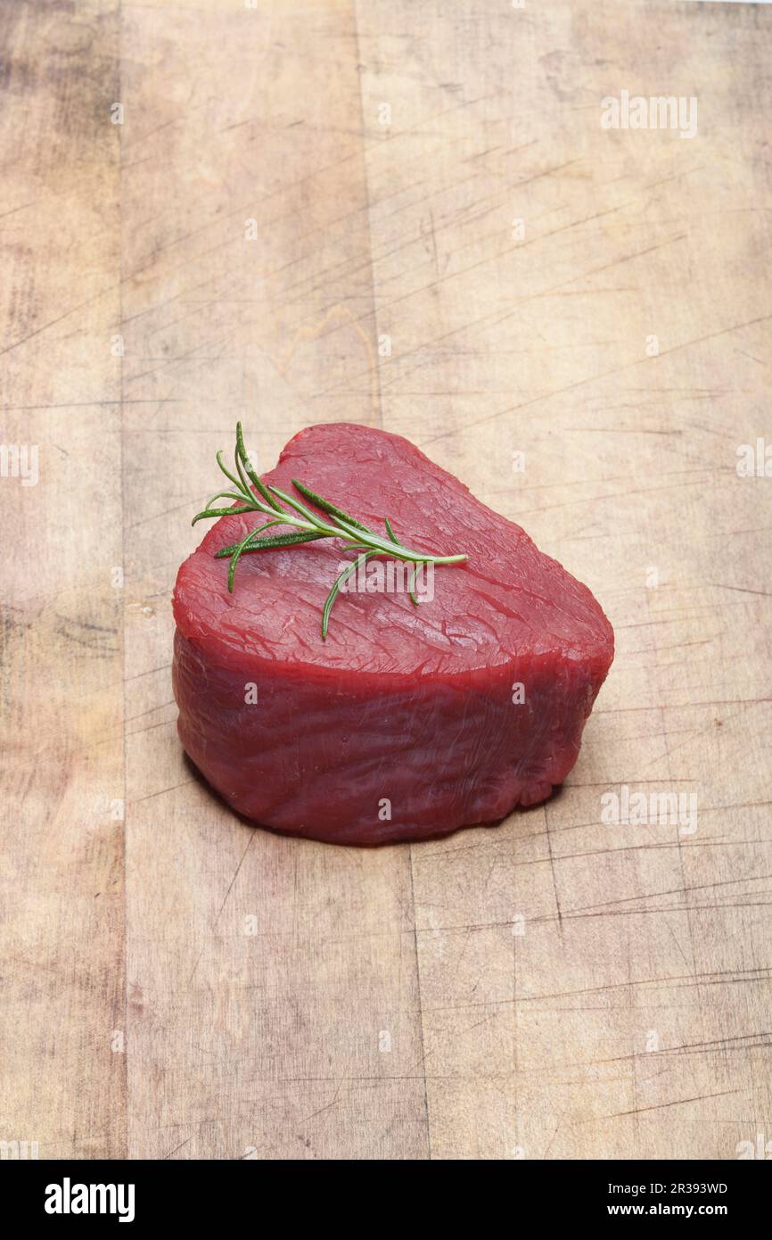 A raw fillet of beef with a rosemary sprig Stock Photo - Alamy