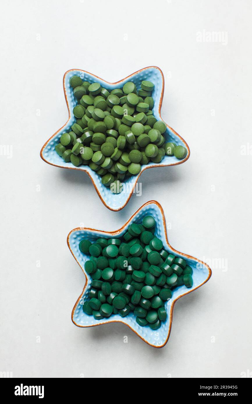 Spirulina algae and chlorella tablets on white marble Stock Photo - Alamy