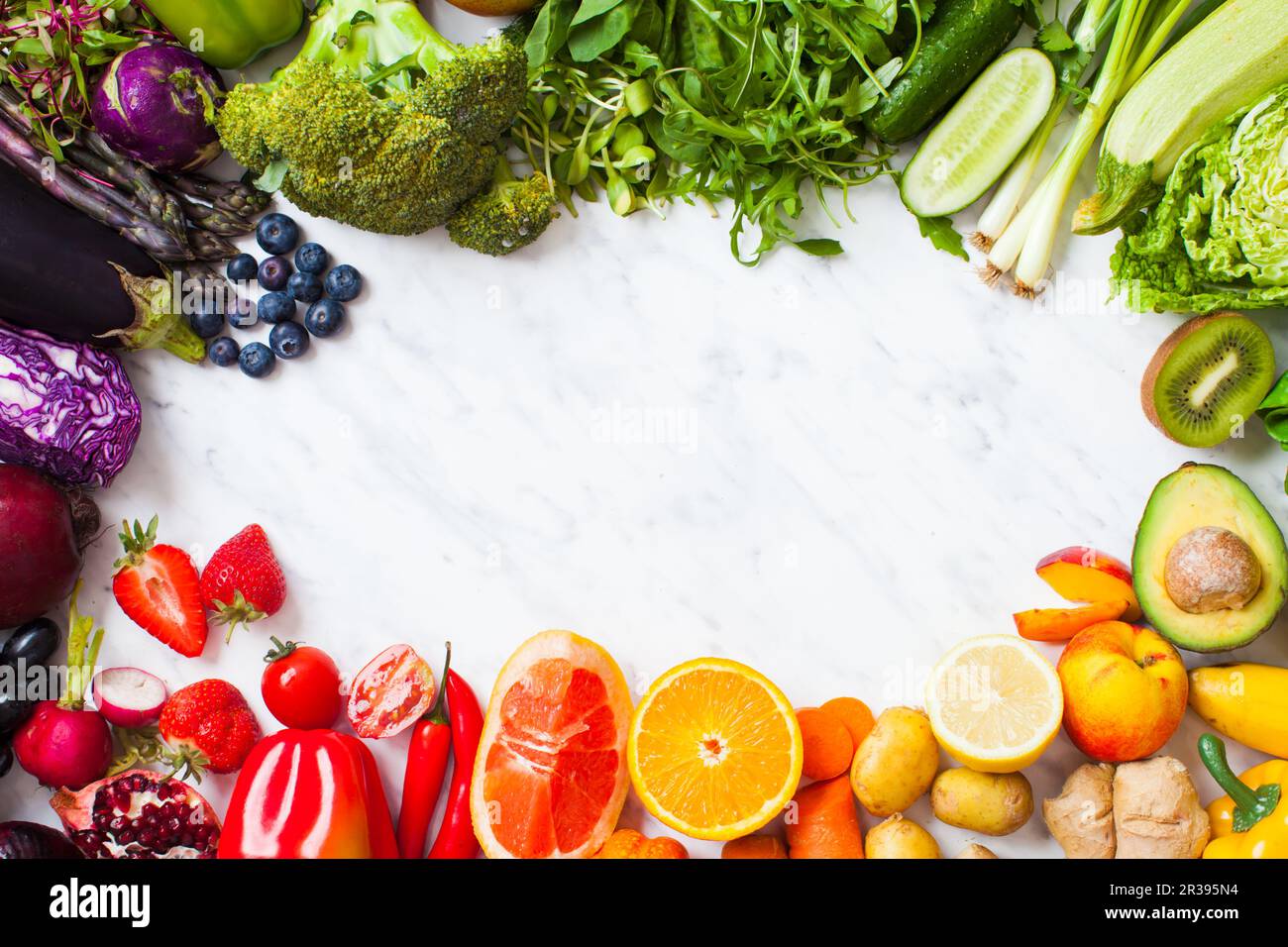 Rainbow colored fruits and vegetables on a white table Stock Photo - Alamy