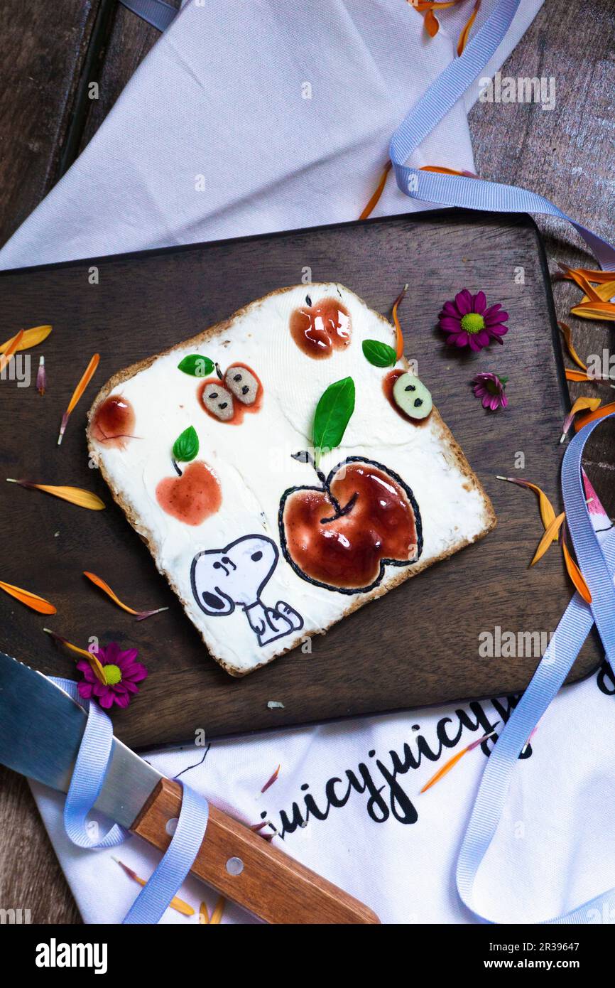 Toast with cream cheese and strawberry jam decorated with Snoopy Stock ...