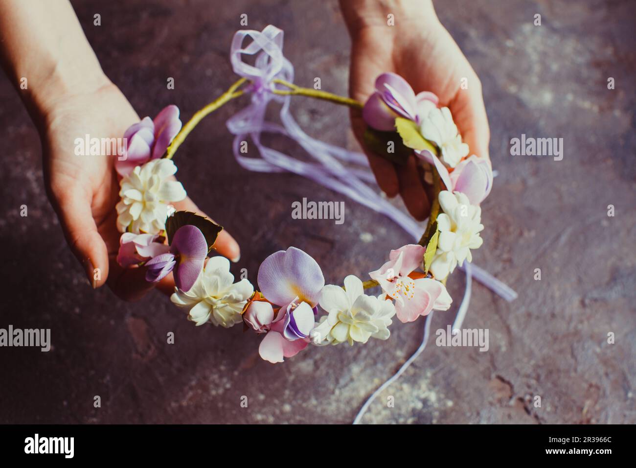 Woman's hands hold foam wreath with sprint flowers Stock Photo - Alamy