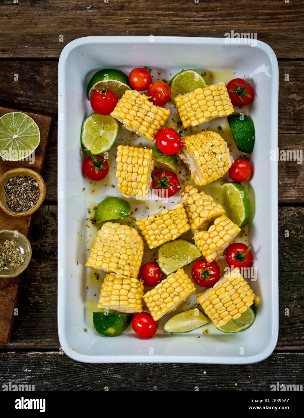 Roasted corn on the cob with cherry tomatoes and limes Stock Photo - Alamy