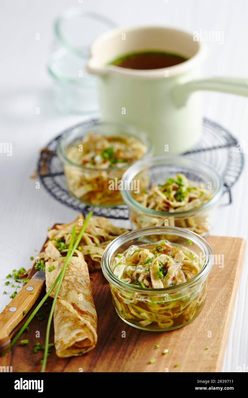 Clear meat broth in jars served with pancake strips Stock Photo - Alamy