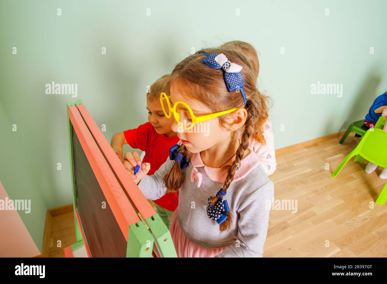 Young teacher, 6 years old girl solves the mathematical problem Stock ...