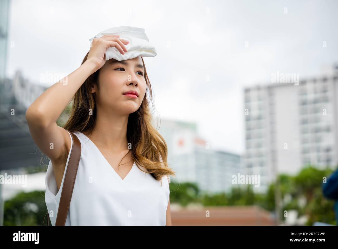 Asian beautiful business woman drying sweat her face with cloth in warm ...