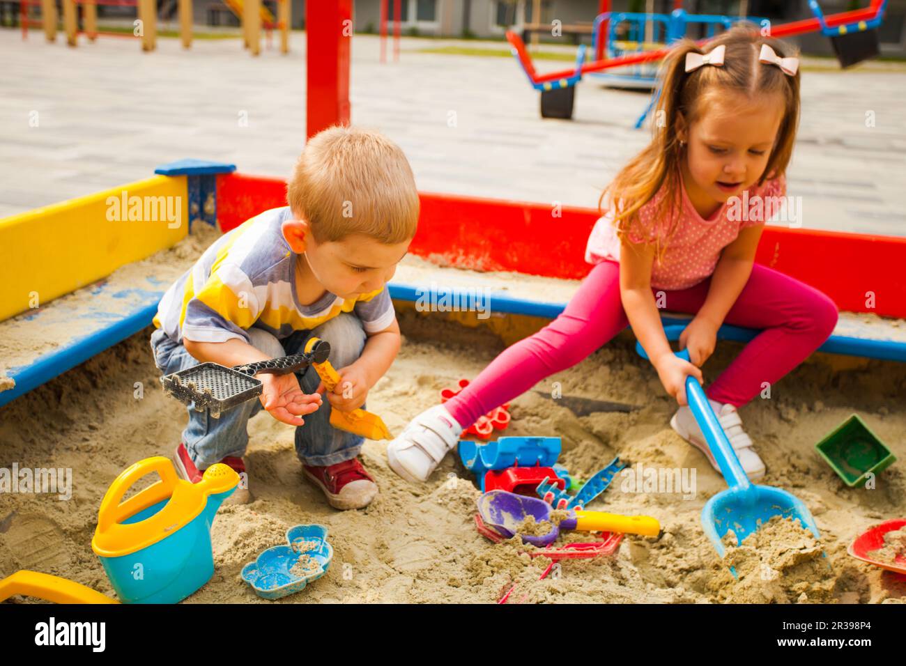 Adorable little kids playing in a sandbox Stock Photo - Alamy