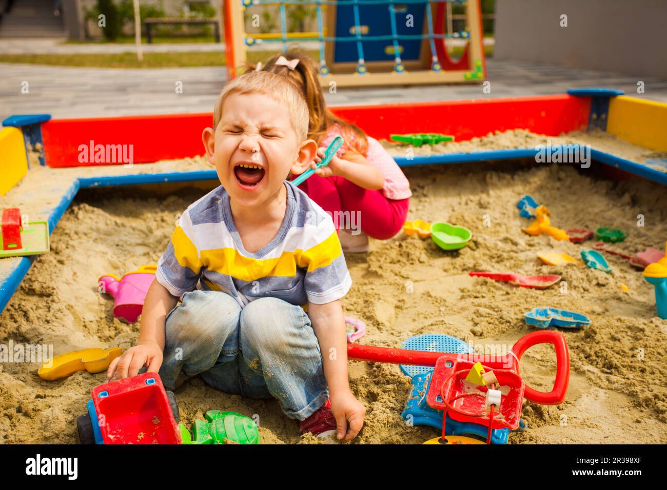 Two grubby kids playing in the sandbox Stock Photo - Alamy