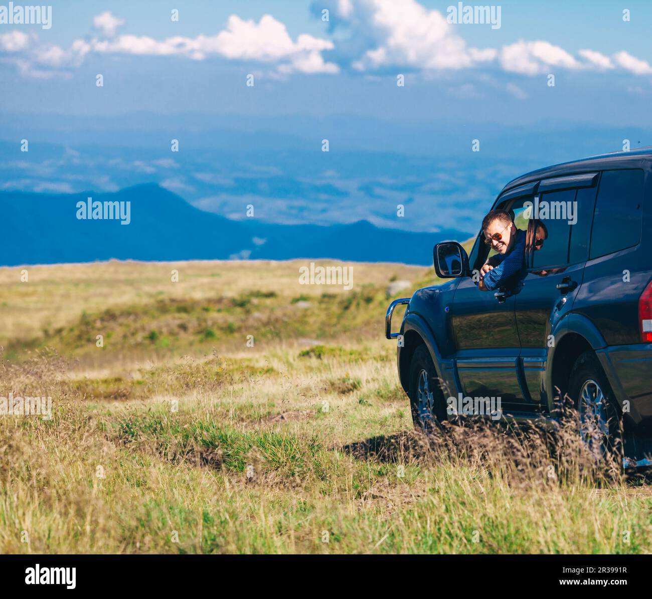Man arrived on an SUV high up in the mountain Stock Photo - Alamy