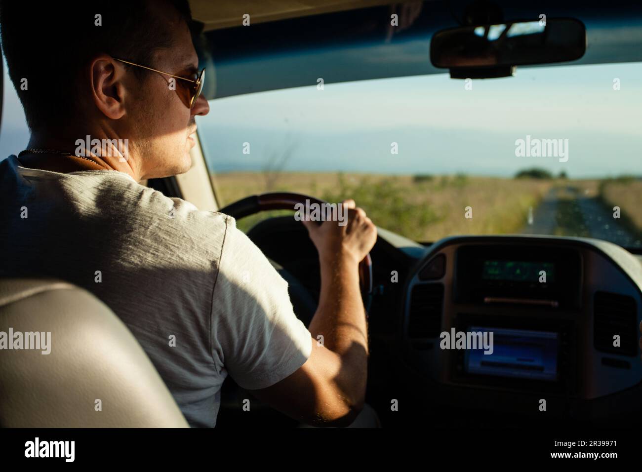 Young man driving car over nature hills background Stock Photo - Alamy