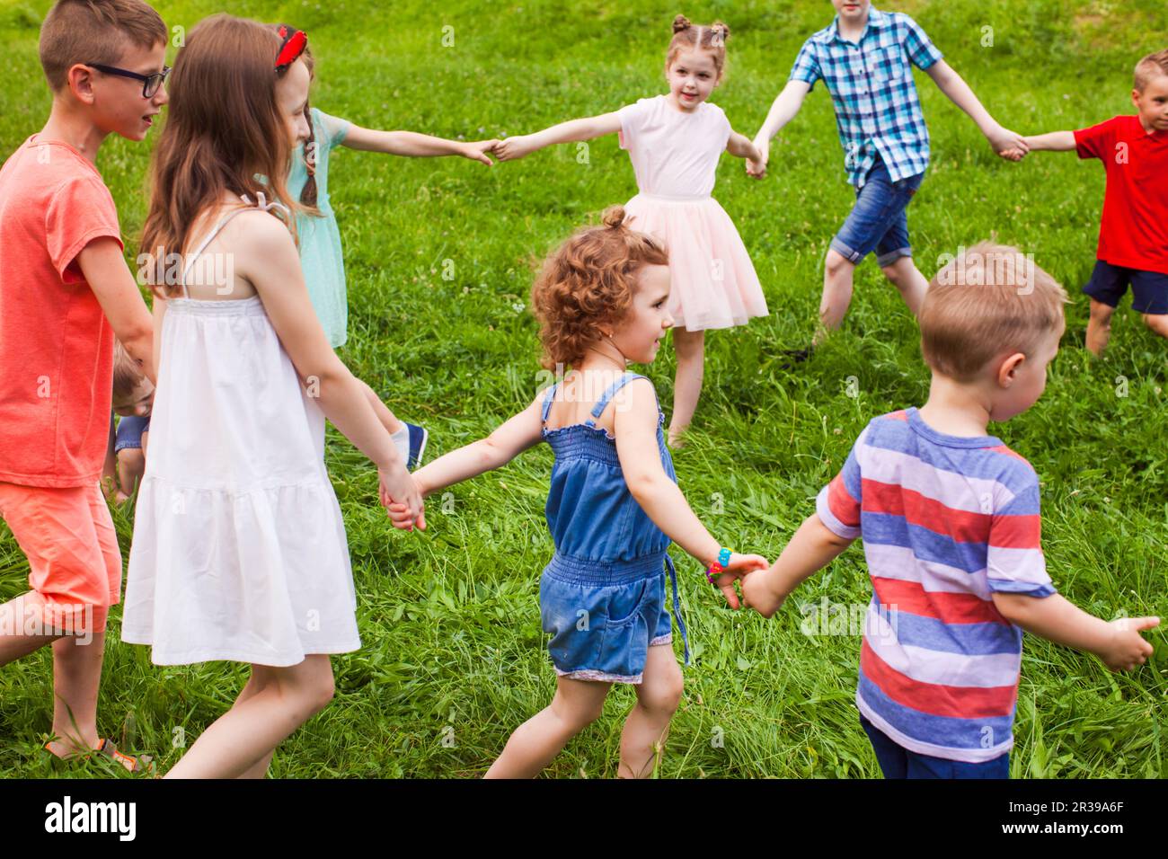 Happy friends doing circle dance on green grass in summer day Stock ...