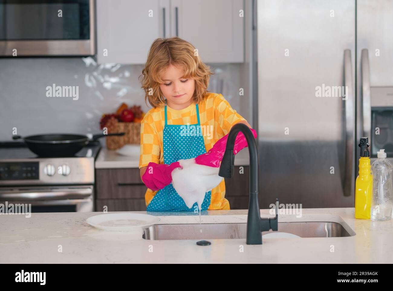 Cleaning house. Cute child helping with household, wiping dishes in ...