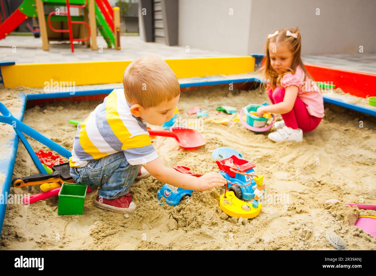 Happy children playing with sand at modern playground outside Stock ...