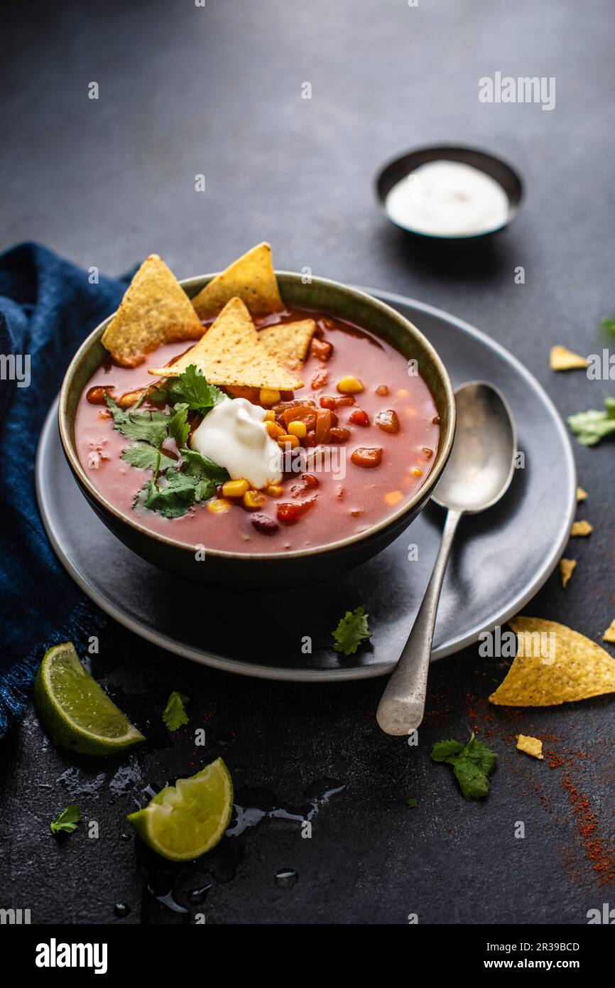 Spicy mexican bean soup with corander, tortillas and sour cream Stock ...