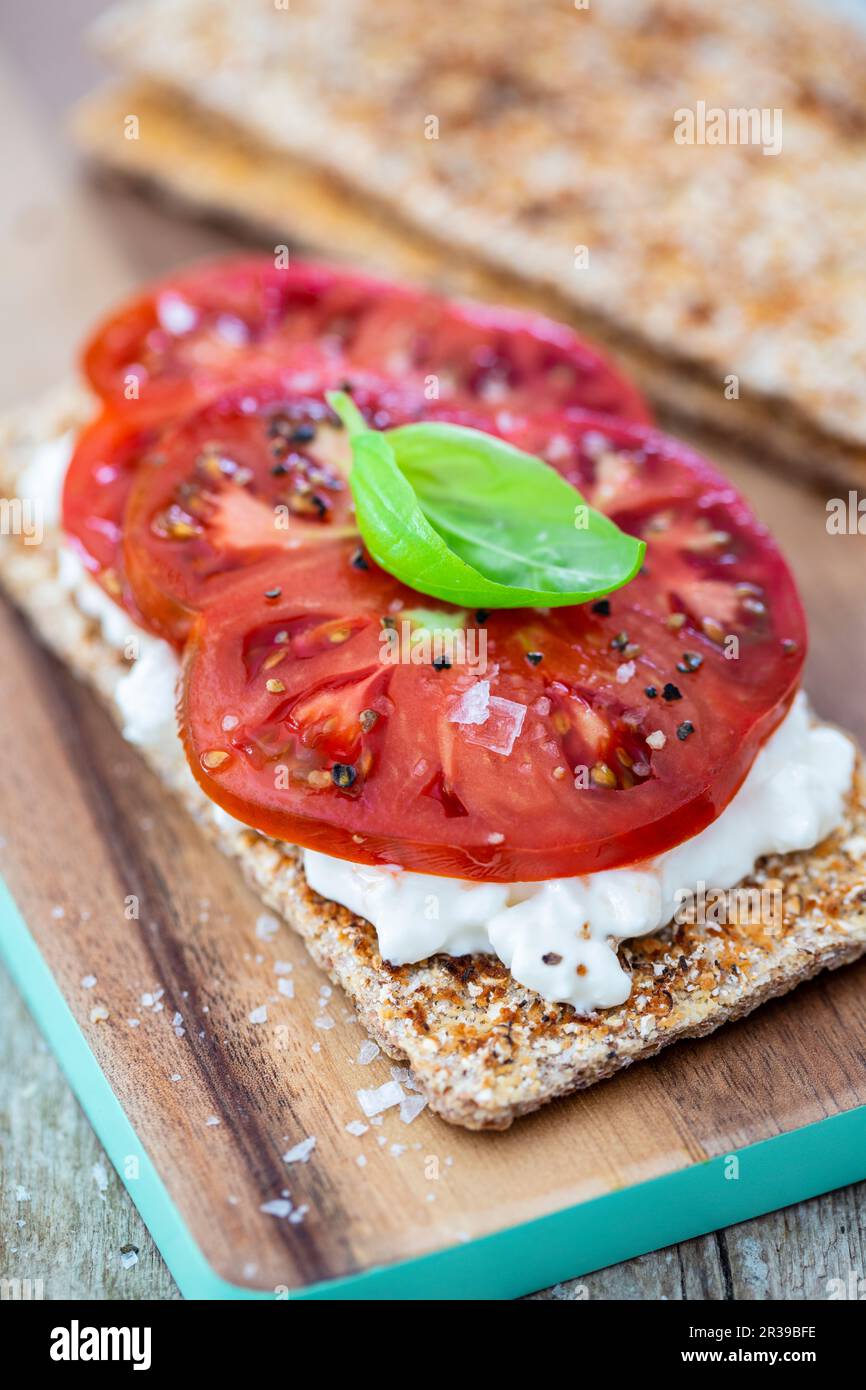 Baked crispbread with cottage cheese and ox heart tomatoes Stock Photo ...
