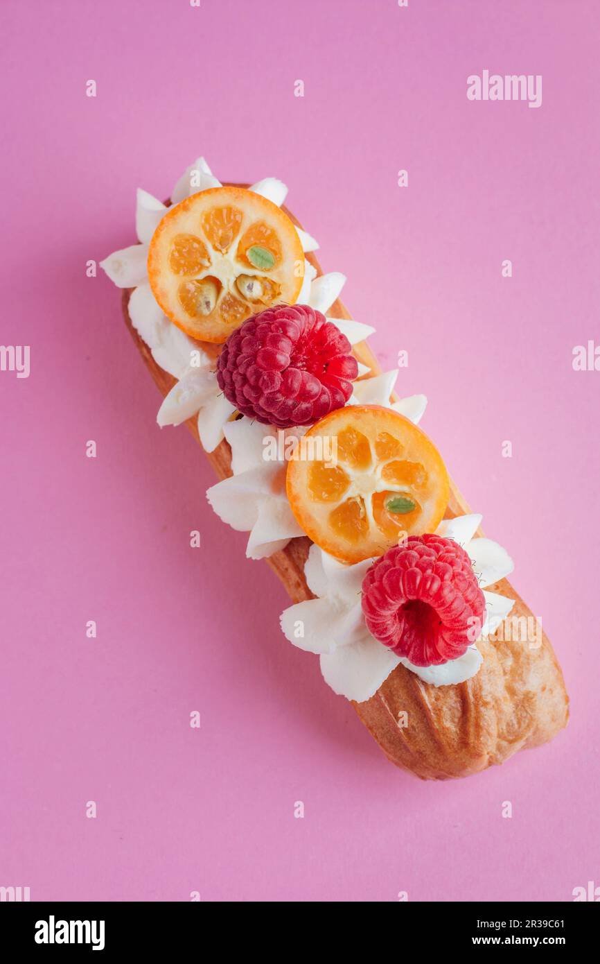 Vanilla eclair with kumquats and raspberries Stock Photo - Alamy