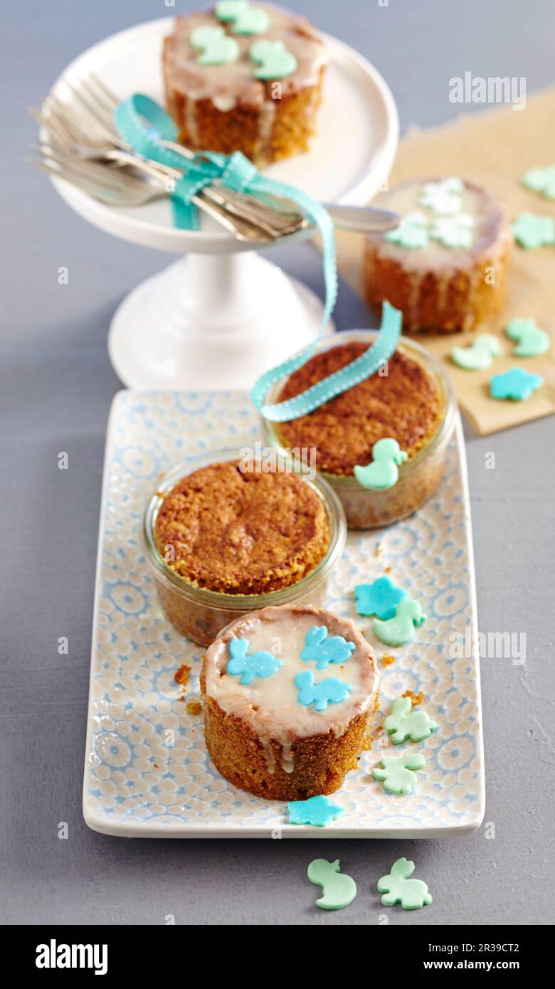 Mini carrot cakes baked in jars decorated with icing and fondant ...