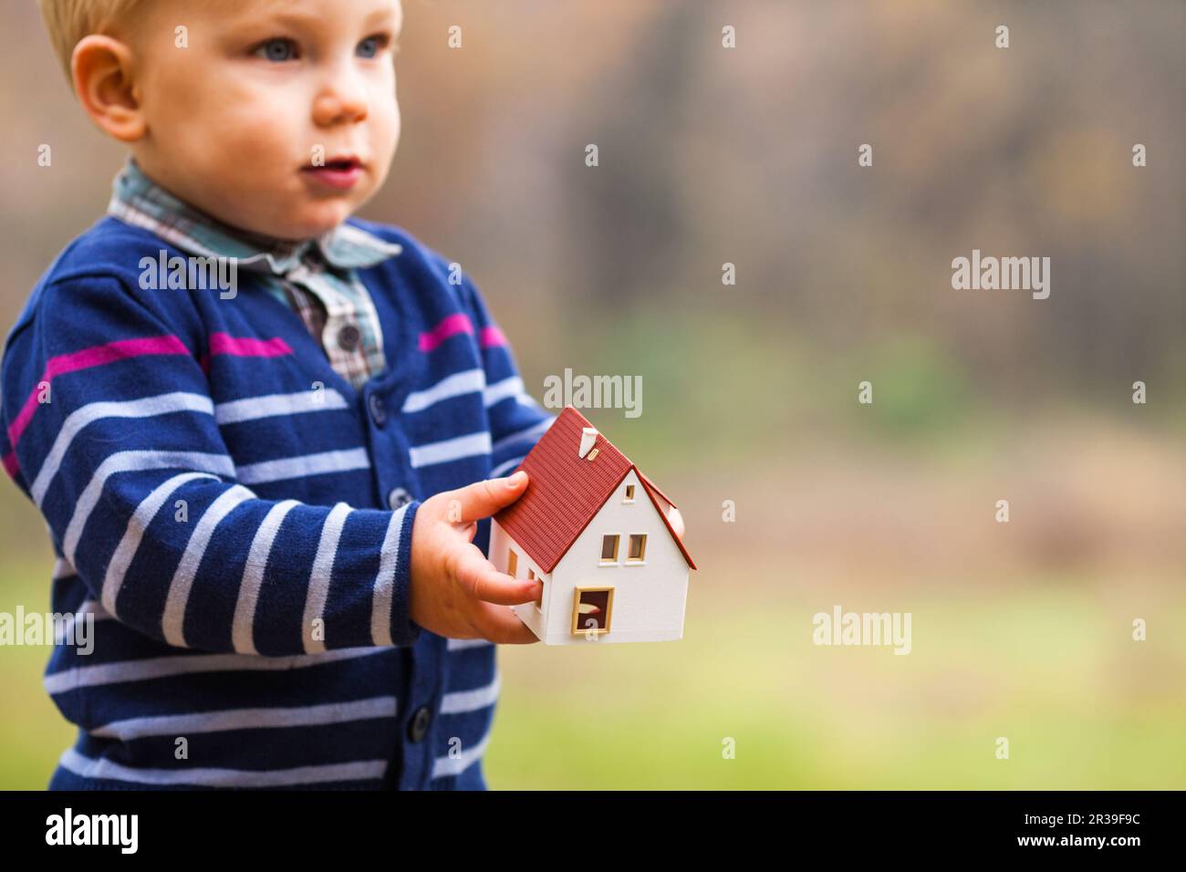 Little child holding model house on nature Stock Photo - Alamy