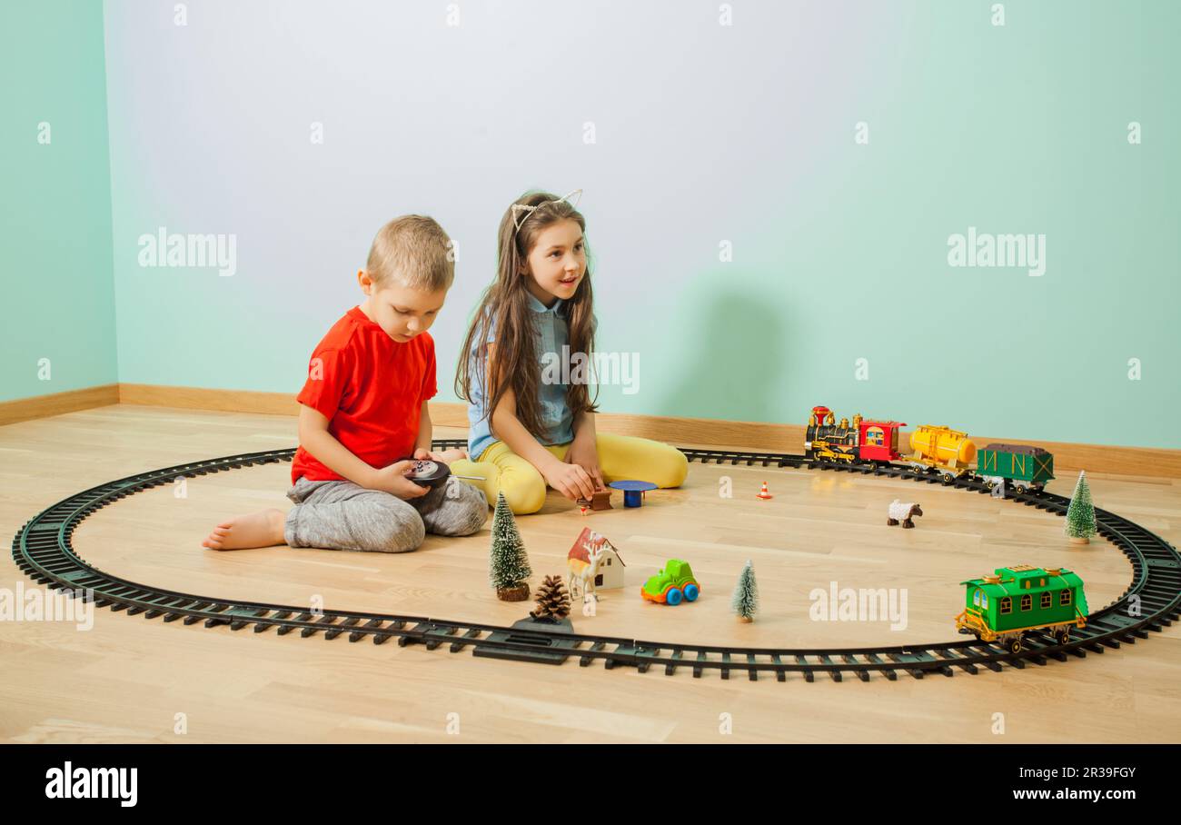 Two happy cute kids playing railway at home Stock Photo - Alamy