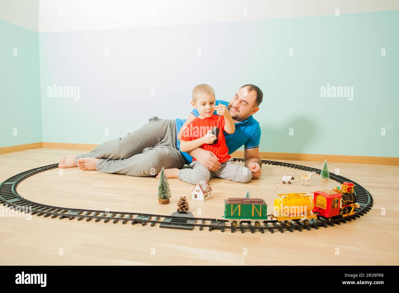 Excited father and child playing with train Stock Photo - Alamy