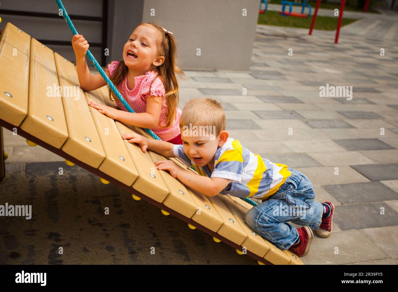 Children trying climbing the rope on playground Stock Photo - Alamy