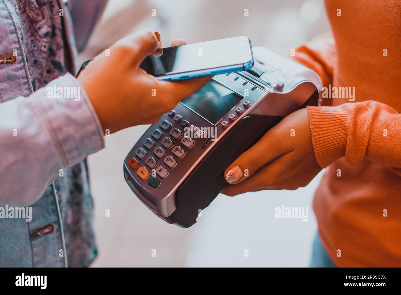 Female customer holding phone near nfc terminal make contactless mobile ...
