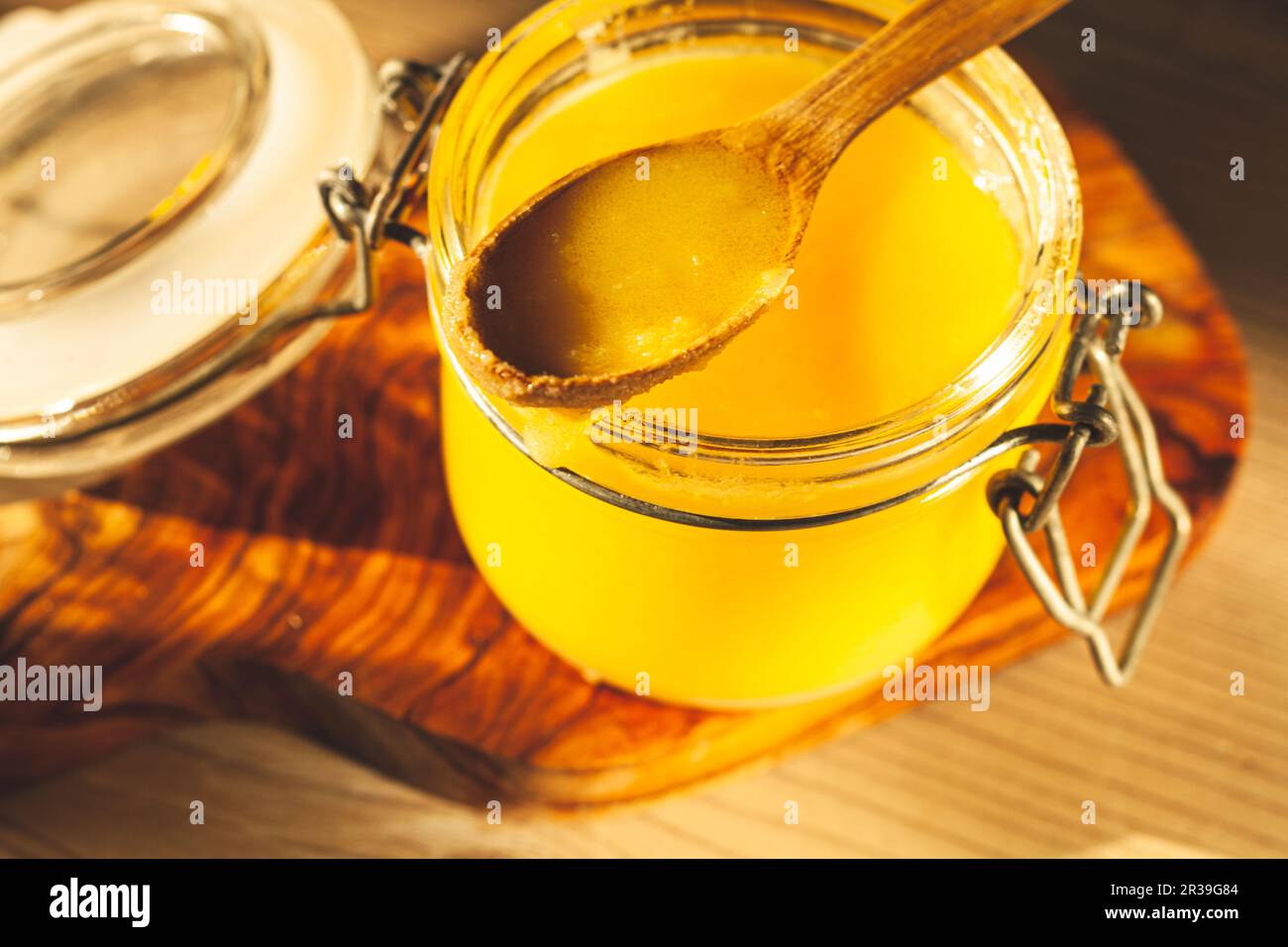 Wooden spoon with ghee - clarified butter in jar Stock Photo - Alamy