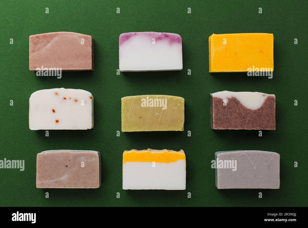 Flat lay composition with handmade soap bars on dark green background ...