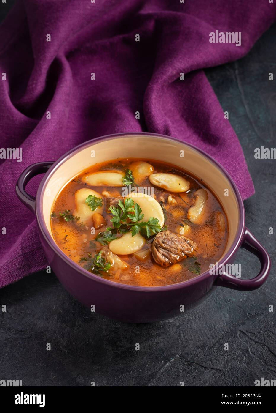 Beef and bean soup on purple background Stock Photo - Alamy