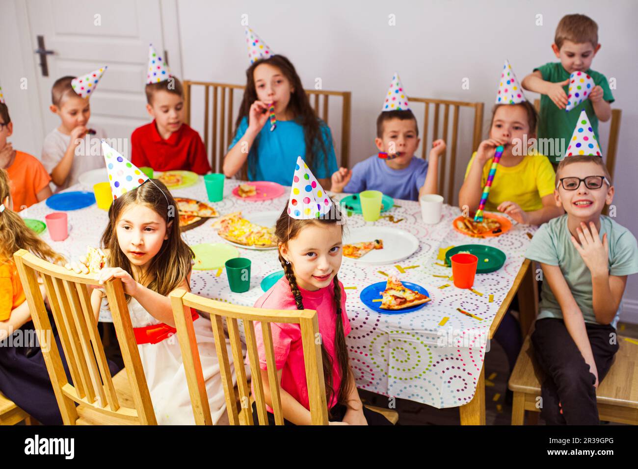 Frendly children celebrating birthday together. Kids eating pizza and ...