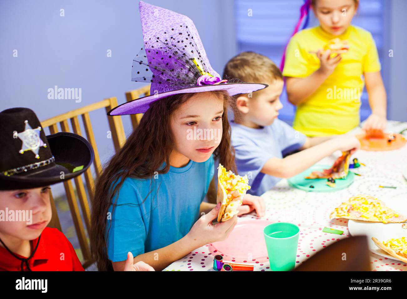Unhappy girl eating pizza at party. Birthday celebration with pizza ...