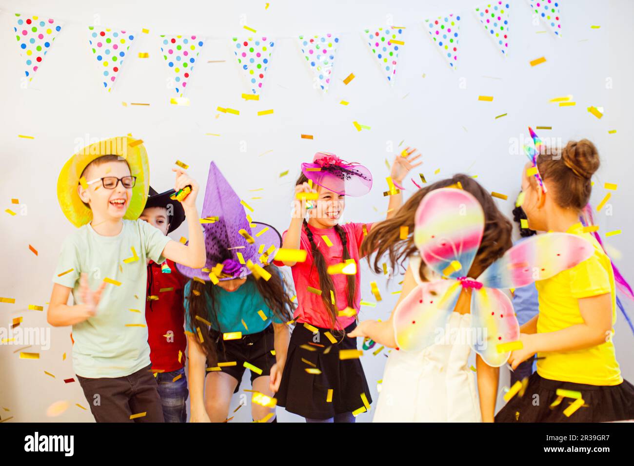 Excited happy children dancing at birthday party. Kids enjoying glitter ...