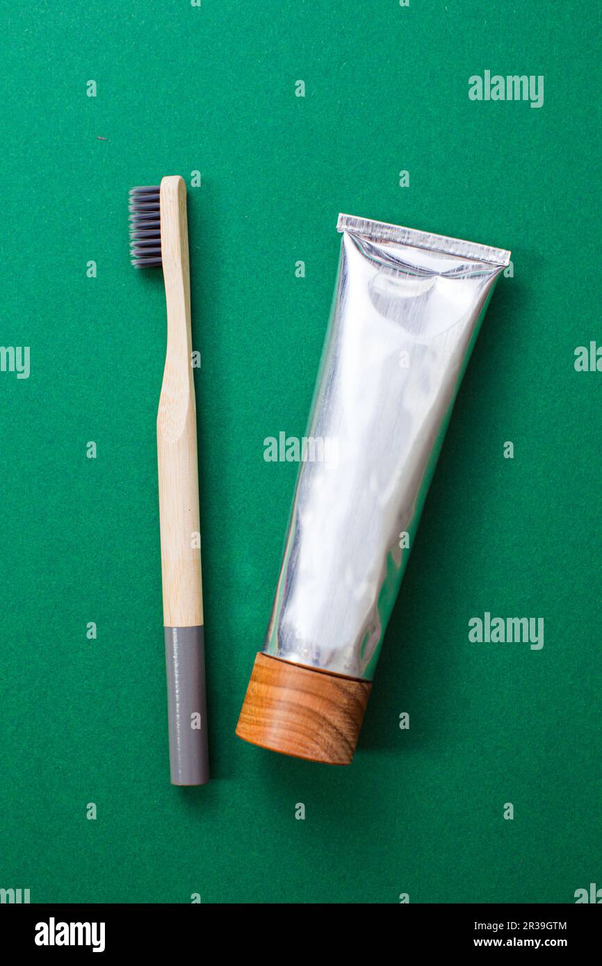 Bamboo toothbrush and organic toothpaste on green background Stock ...