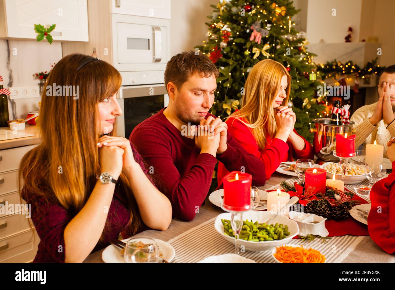 Adult brothers and sisters praying before Christmas dinner Stock Photo ...