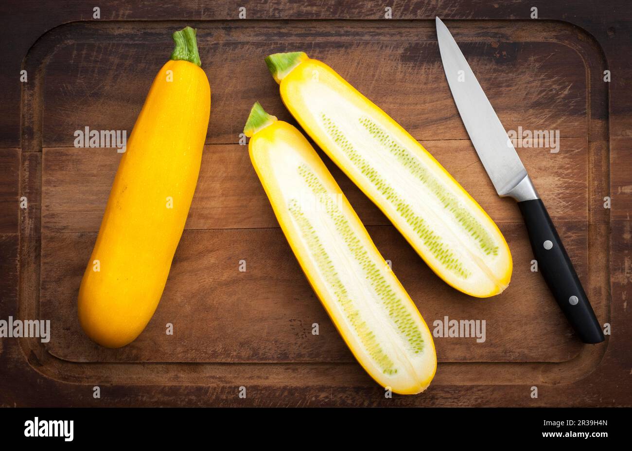Two yellow courgettes, one whole and one halved Stock Photo - Alamy