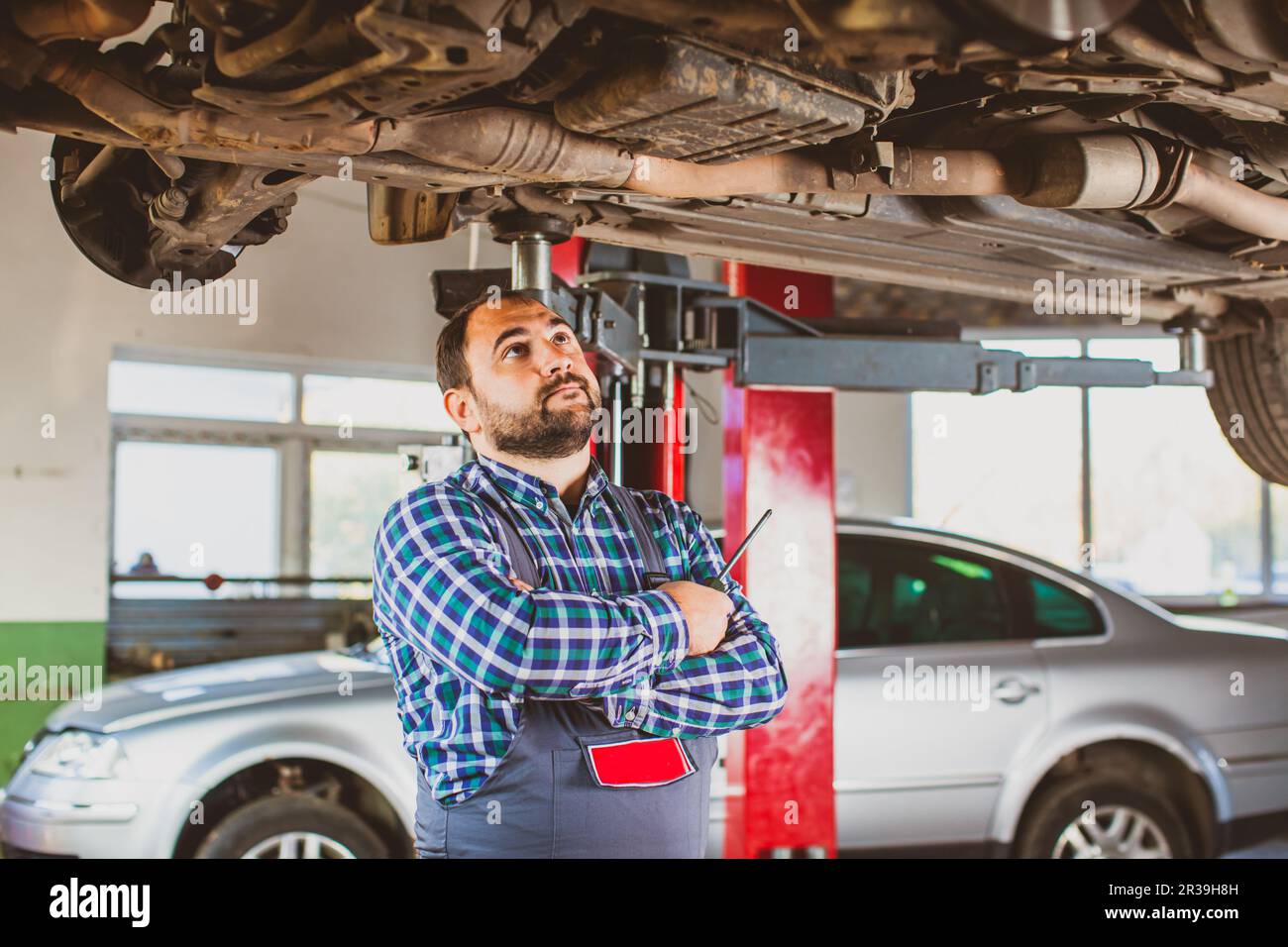Thoughtful mechanic examining car at the workplace Stock Photo - Alamy