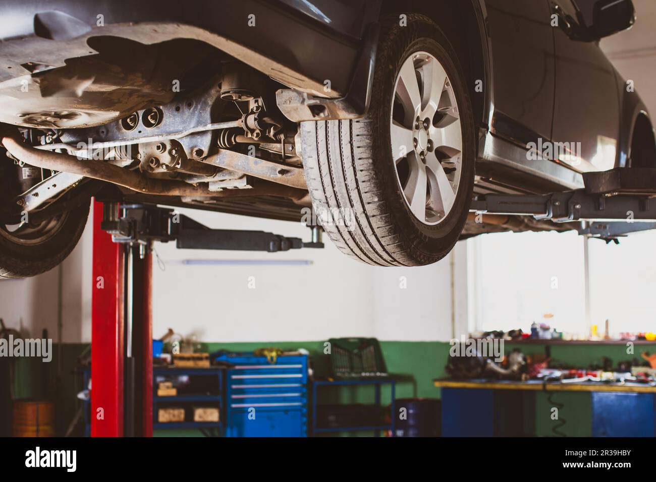 Vehicle raised on lift at maintenance station Stock Photo - Alamy