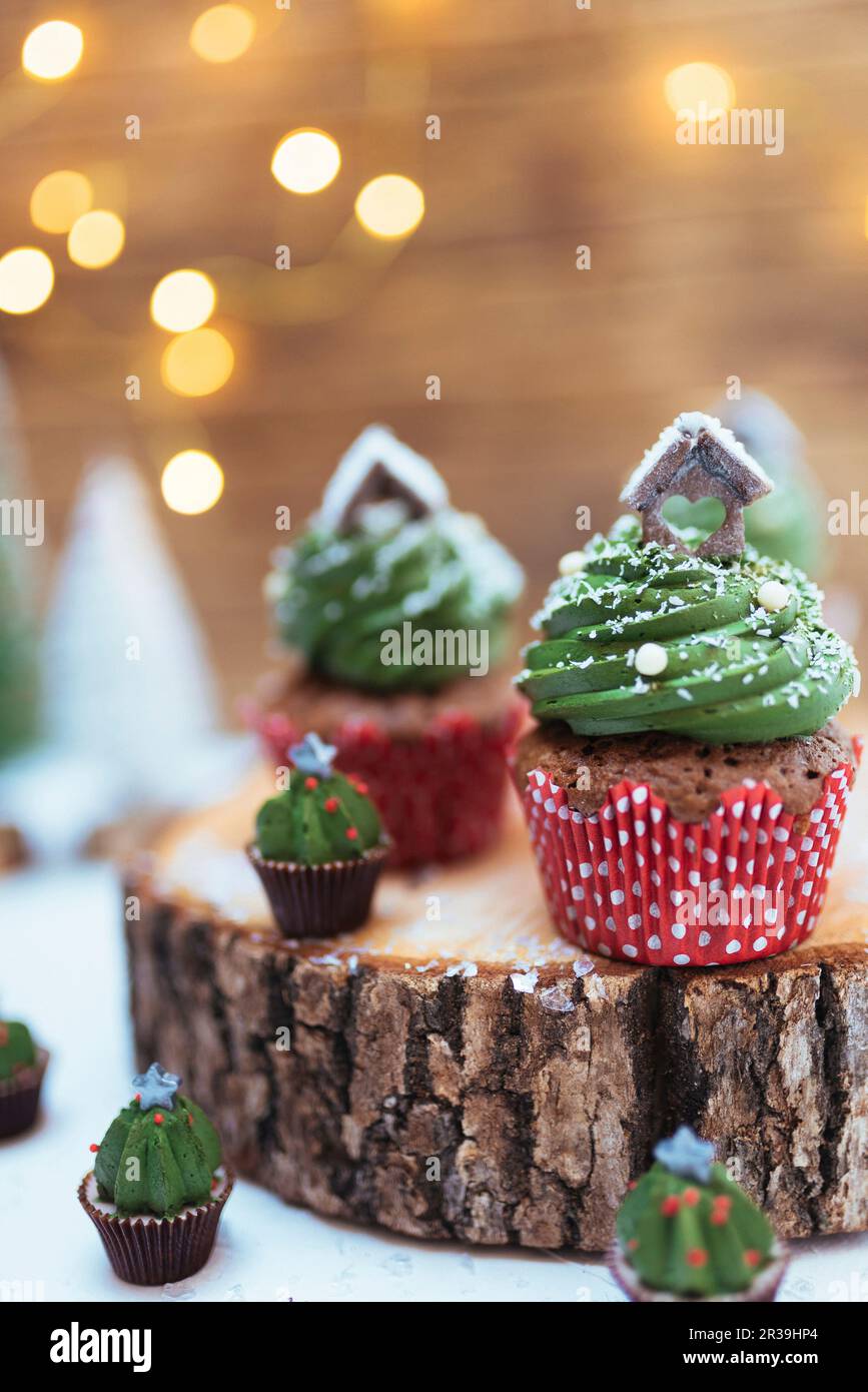 Christmas chocolate muffins with creamy green frosting on a log slice ...