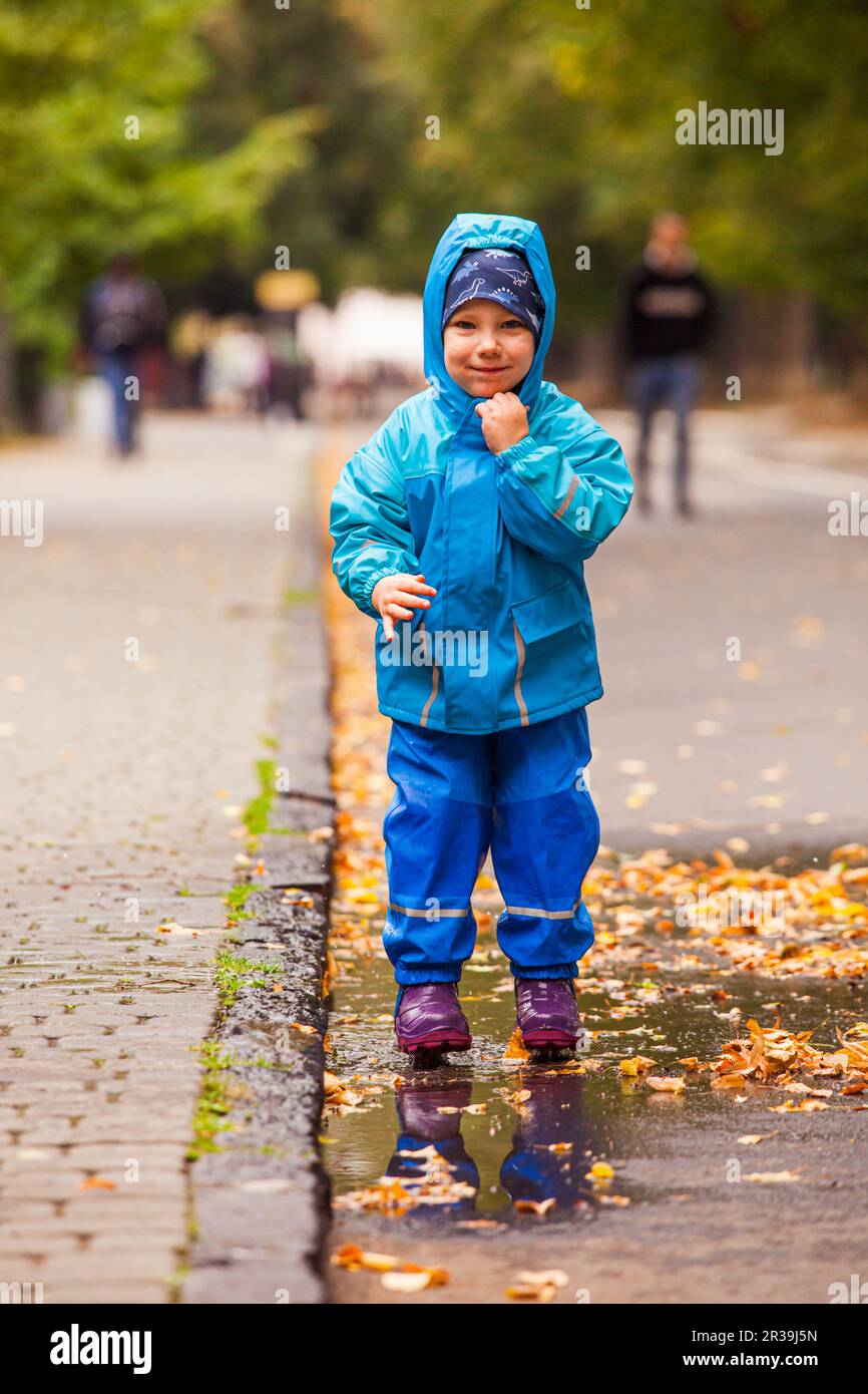 The boy rejoices in the puddle in the autumn park Stock Photo - Alamy