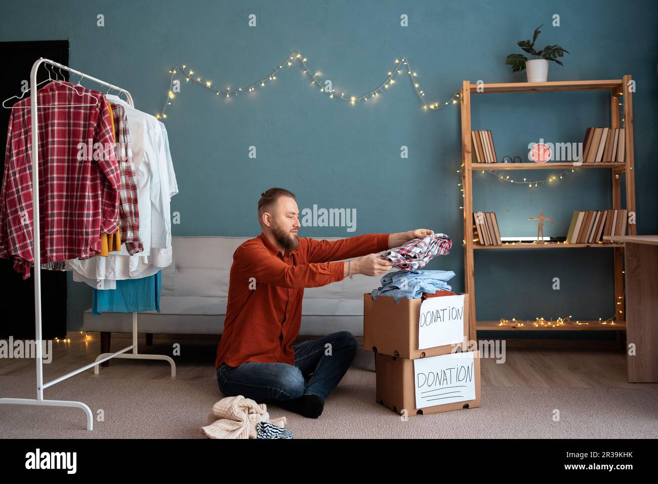 Man collect and packing clothes in box for donation and reuse recycle ...